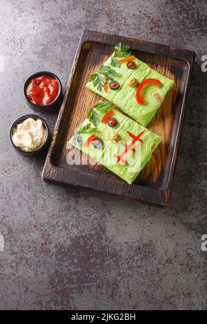 halloween fast food spinach burrito sandwich with funny face on wooden ...
