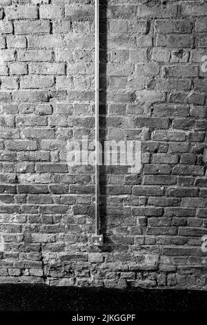 Electrical plug on a brick wall with a cord or extension cord plugged ...