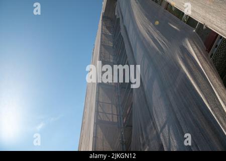 scaffolding: a building covered with a white sheet against the fall of ...