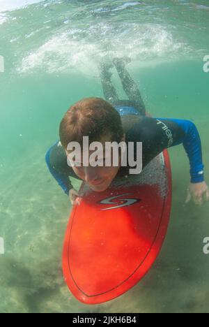 Surfer duck diving a wave when paddling out, West Dale, Wales, UK Stock ...