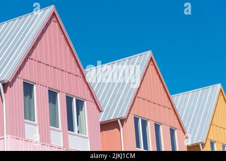 Lookup view of metal roof and gutter on row of new development colorful ...