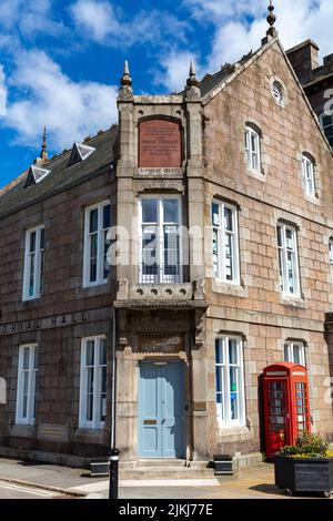 The high street shops of the town of Ballater on a partly cloudy day ...