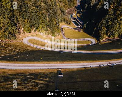 A bird's eye view of a road surrounded by the fish pond and a field at ...