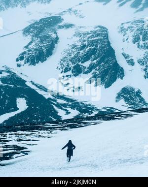 A vertical shot of snowy mountains against the background of the cloudy ...