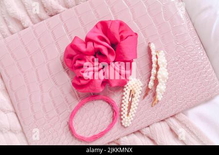 Set of pearl hairpins and elastic bands on pink background . High ...