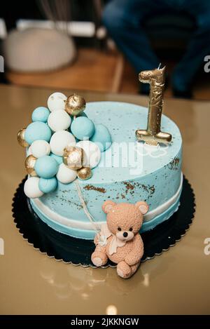 A vertical shot of blue balloons, birthday decorations, and cupcakes ...