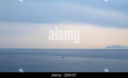 A single boat far away in the sea water Stock Photo - Alamy