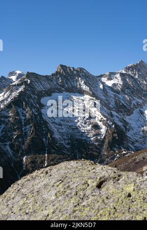 A vertical shot of mountains covered in forests on a cold foggy winter ...