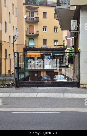 Shops opposite to a road seen through gates Stock Photo - Alamy