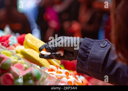 Candy store, unrecognizable hand picking up sweets in a market in ...