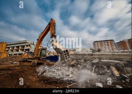 Excavator with hydraulic press breaks concrete leftovers Stock Photo - Alamy