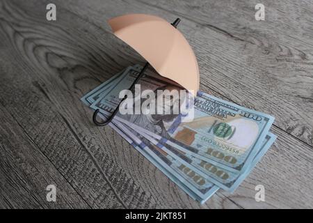 Stack of money and umbrella for protection with copy space. Financial ...
