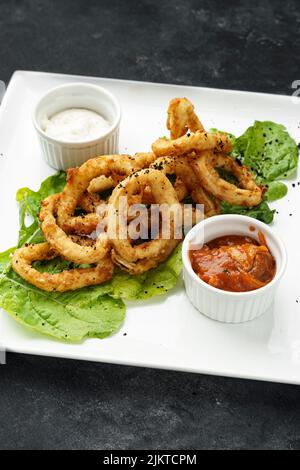 A vertical shot of crispy onion rings with a dip Stock Photo - Alamy