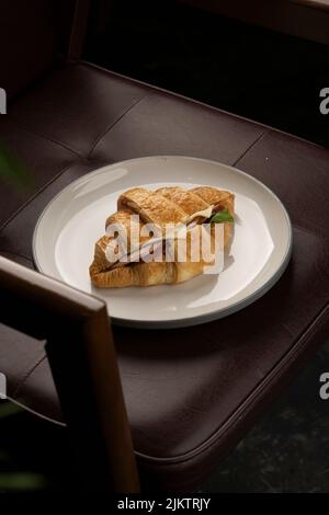 A closeup shot of a croissant sandwich on a newspaper Stock Photo - Alamy