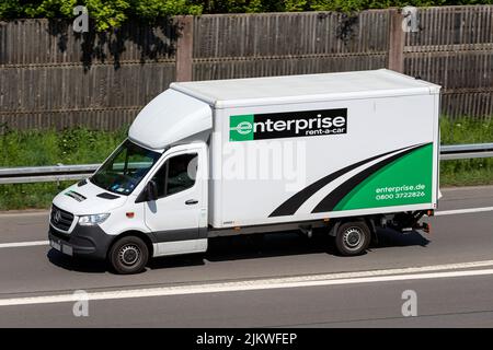 A Mercedes Sprinter enterprise rental van driving on a main road in the ...