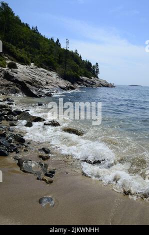 Foamy waves calmly splashing on the sandy beach in summer Stock Photo ...