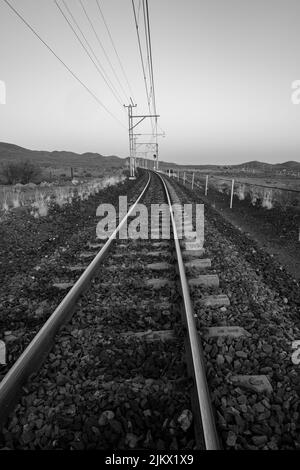 A grayscale shot of an old railway bridge in the mountains at ...