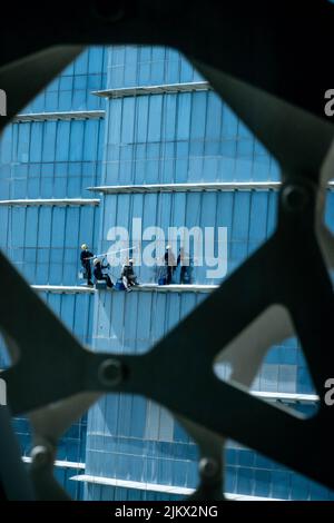A vertical shot of men cleaning the windows of towers in Doha, Qatar ...