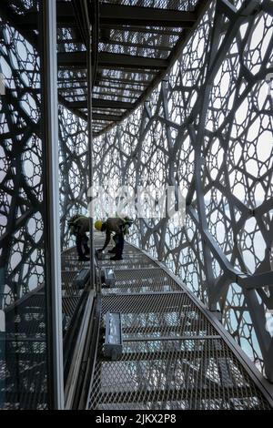 A vertical shot of men cleaning the windows of towers in Doha, Qatar ...