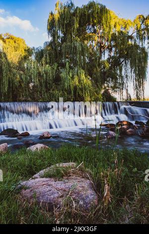 A vertical shot of a small waterfall in a forest Stock Photo - Alamy