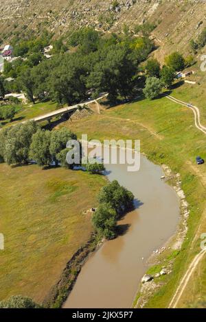 Beautiful natural gorge strewn with hills, grass and trees. At bottom ...
