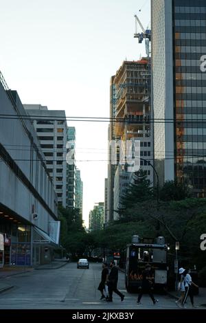 A vertical shot of tall modern buildings and a busy street in downtown ...