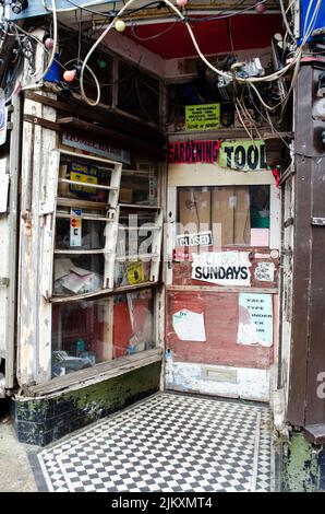 An old fashioned hardware store with multiple bright and torn signs ...