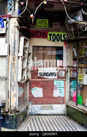 An old fashioned hardware store with multiple bright and torn signs ...