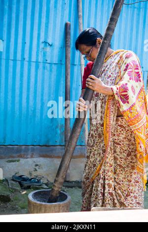 Pesting beans in a Ukhal musal (Mortal and Pestle) also known as Gail ...