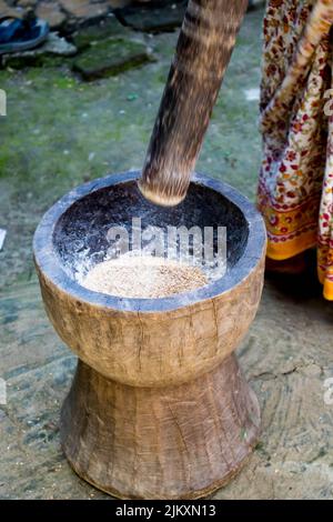 Pesting beans in a Ukhal musal (Mortal and Pestle) also known as Gail ...