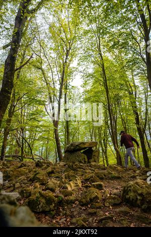 A man on top of the Aitzetako Txabala Dolmen in the Basque Country ...