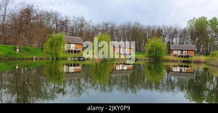 The beautiful shot of a riverside resort houses and tree reflection on ...