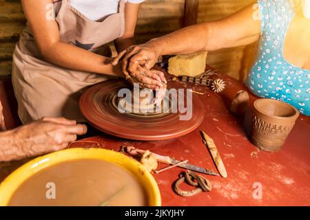 Unrecognizable artisan teaching how to mold handicrafts on an artisan ...