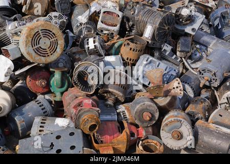 Close-up of discarded electric motors at scrap metal recycling junkyard ...