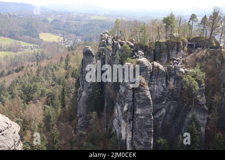 A scenic view of Bashtai rock formations covered with trees on a sunny ...