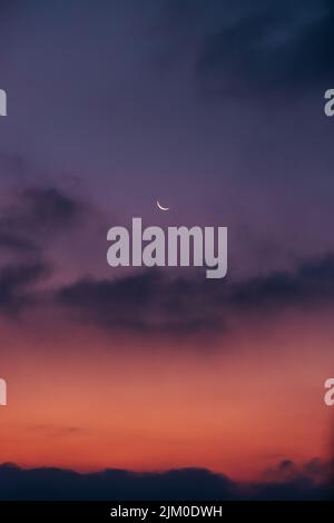 A vertical shot of the crescent moon in the blue evening sky Stock ...