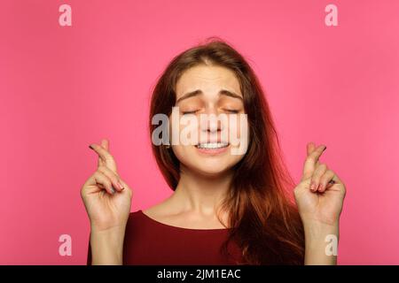 woman keep fingers crossed hope luck emotional Stock Photo - Alamy