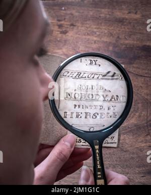 Curator Sarah Laycock uses a magnifying glass to inspect the last ...