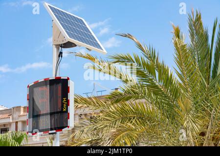 Informative digital speed sign with solar panel, on the street of a ...