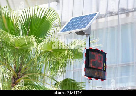 Informative digital speed sign with solar panel, on the street of a ...