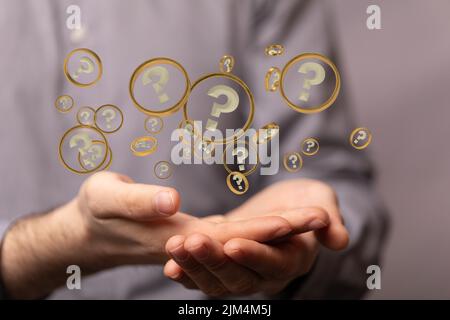 A person's hand with illustrative question mark icons floating above hands Stock Photo - Alamy