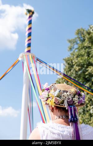 A vertical shot of a traditional English Maypole dancer with a floral ...