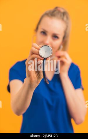 Young blonde woman wearing doctor uniform using laptop working at ...