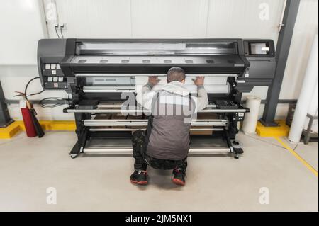 Technician worker operator changes the paper roll on large premium ...