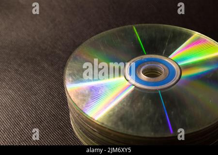 Some old Compact Disk, DVDs stacked in a black surface Stock Photo - Alamy