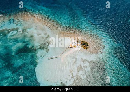 An aerial top view of the Goff's Caye island in the Caribbean Sea ...