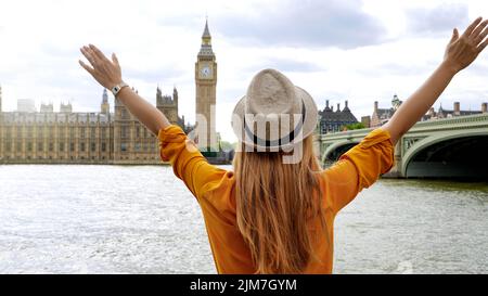 Enthusiastic traveler student girl with raised arms in London enjoying ...