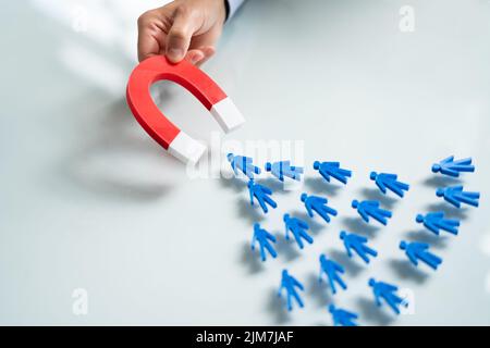 Close-up Of A Human Hand Attracting White Human Figures With Horseshoe ...