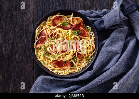 Fried Turkey Scampi Pasta in frying pan on dark wooden table ...
