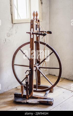 An antique wooden spinning wheel. Vertical photo Stock Photo - Alamy